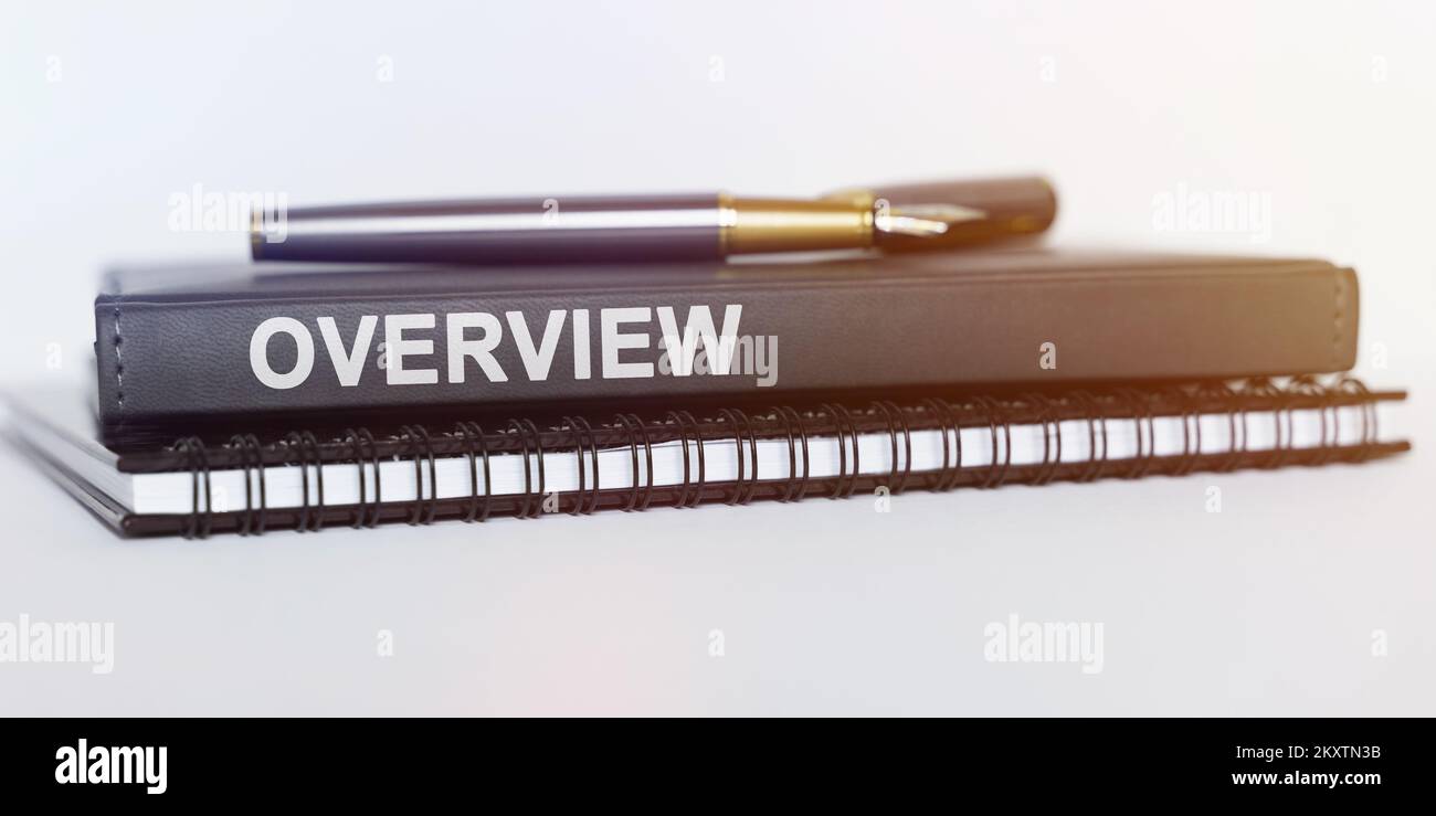 Business and finance concept. On the table are a notebook, a pen and a book. The book says ...