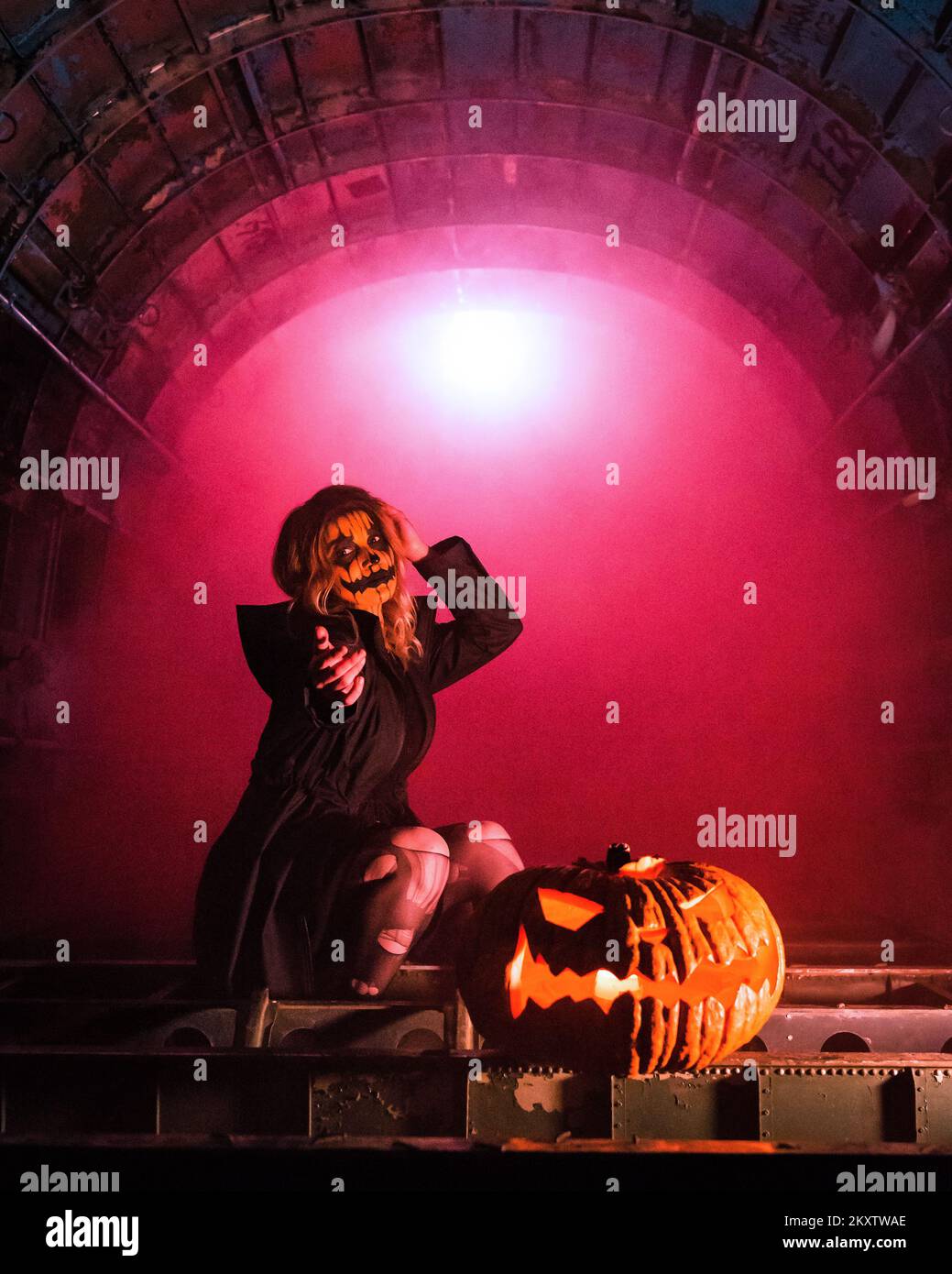 A woman dressed in a scary pumpkin costume pose to photographer prior ...