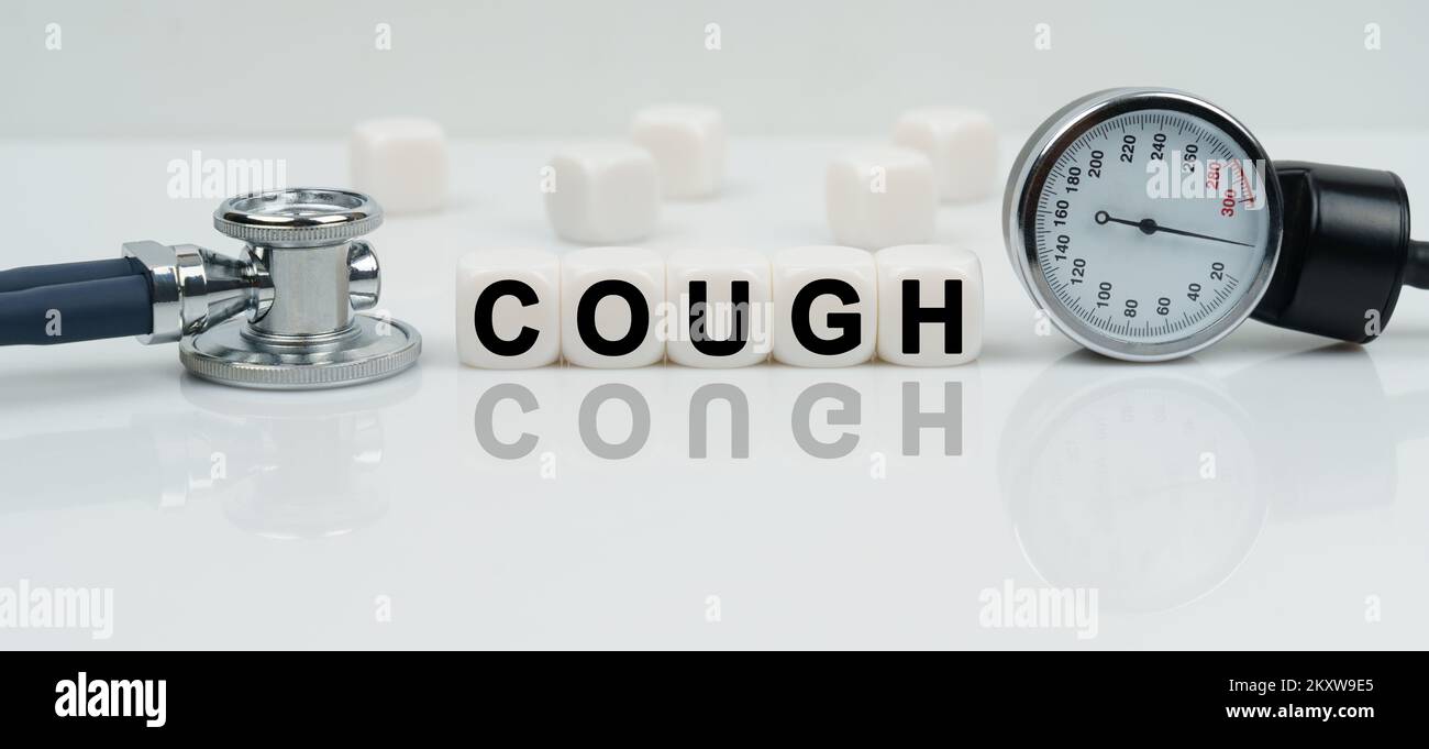 Medicine concept. On a reflective white surface lies a stethoscope and ...