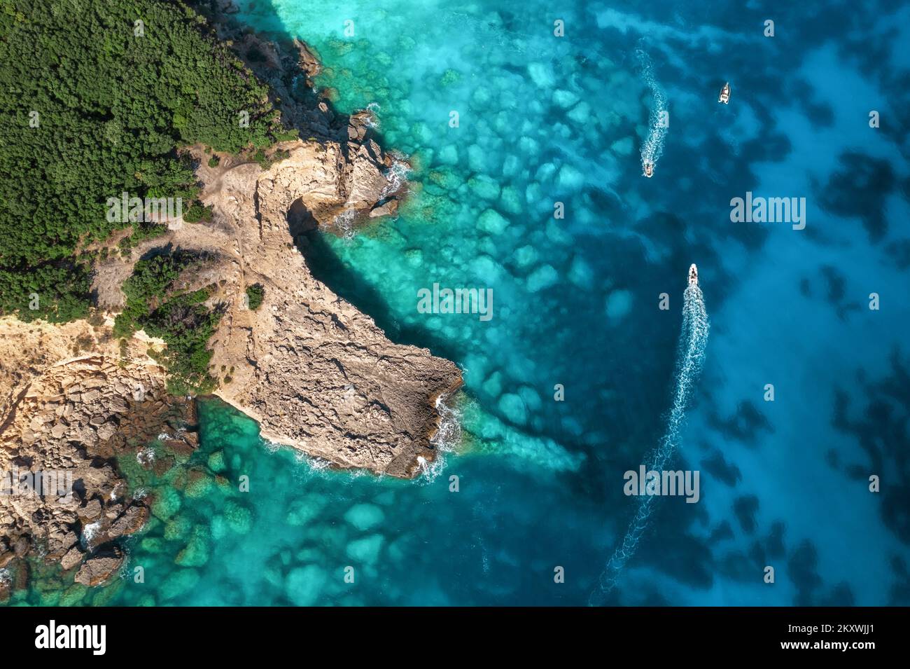 summer seascape. Turquoise sea water, rocks and boats from top view ...