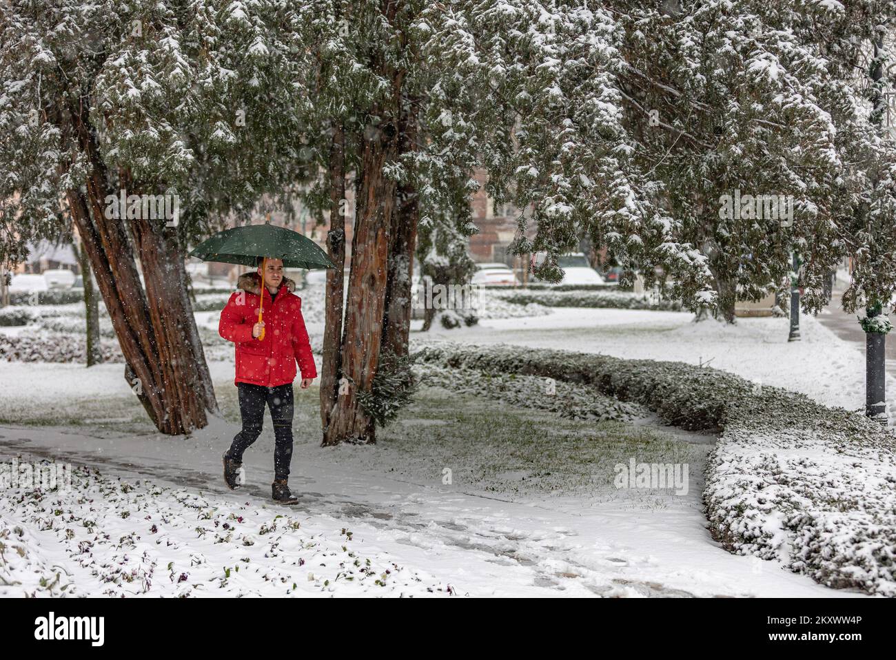 People walk on a snow-covered street in Osijek, Croatia, on December 27 ...
