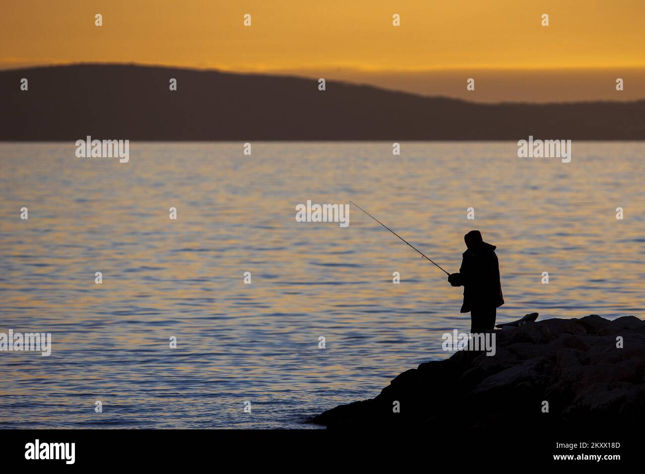 A fisherman is silhouetted during a sunset in Split, Croatia on January ...