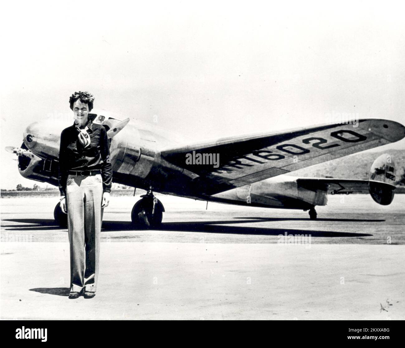 Amelia Earhart standing in front of the Lockheed Electra in which she ...