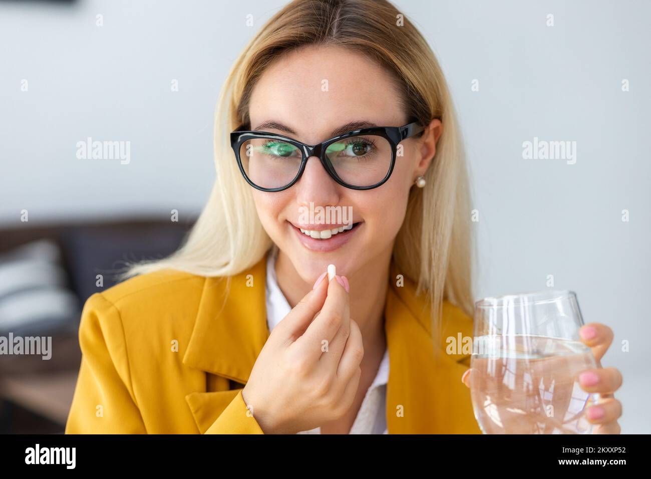 Happy Woman Holding Vitamin Capsule And Glass Of Water Looking At Camera And Smiling Friendly