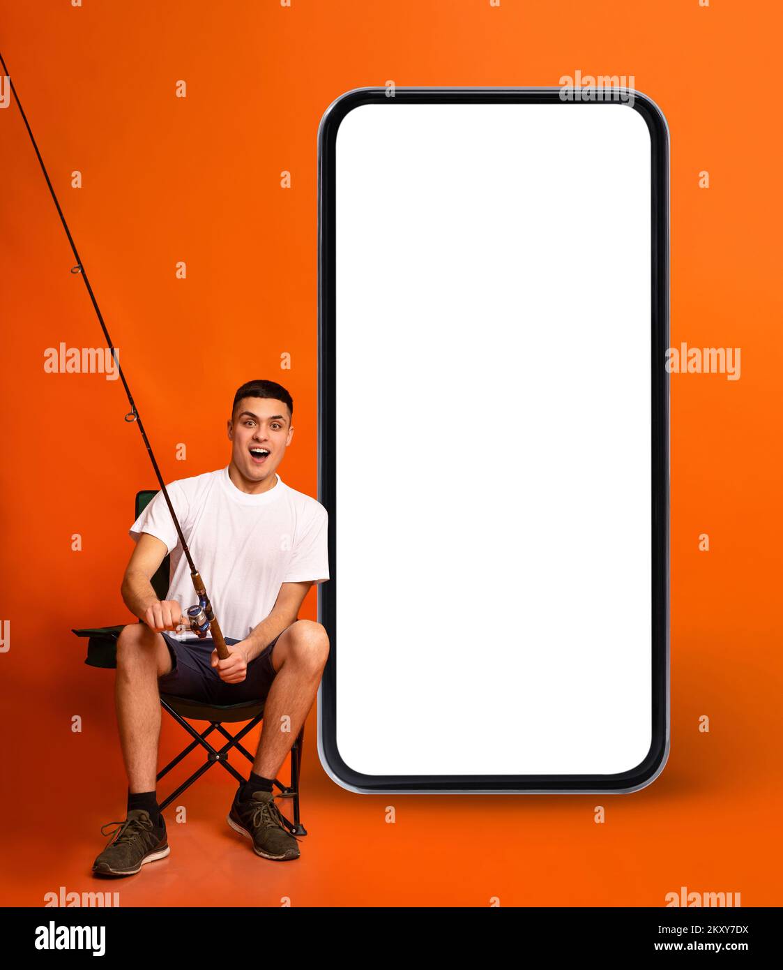 Excited Young Man With Fish-Rod Sitting Next To Big Blank Smartphone ...