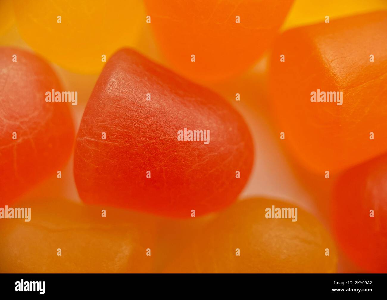 Close-up texture of orange and yellow multivitamin gummies on white ...