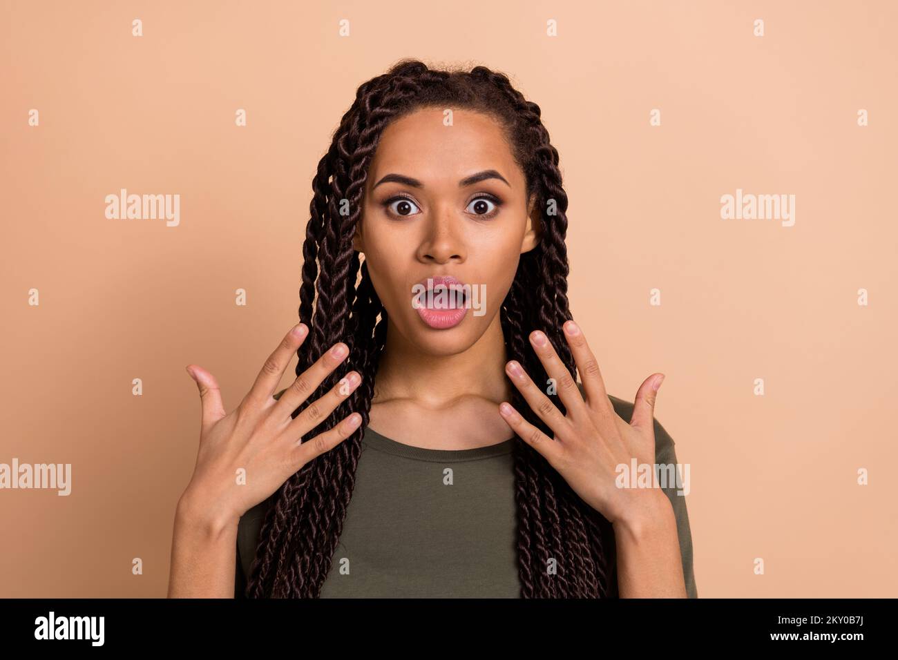 Portrait of young scared horrified woman hear negative news feel worried isolated on beige color ...