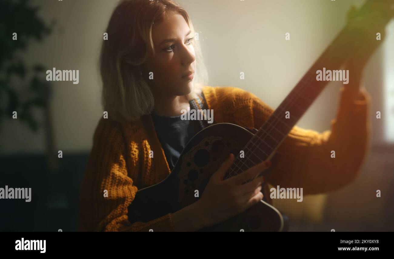 Teenage girl learning to play acoustic guitar Stock Photo - Alamy
