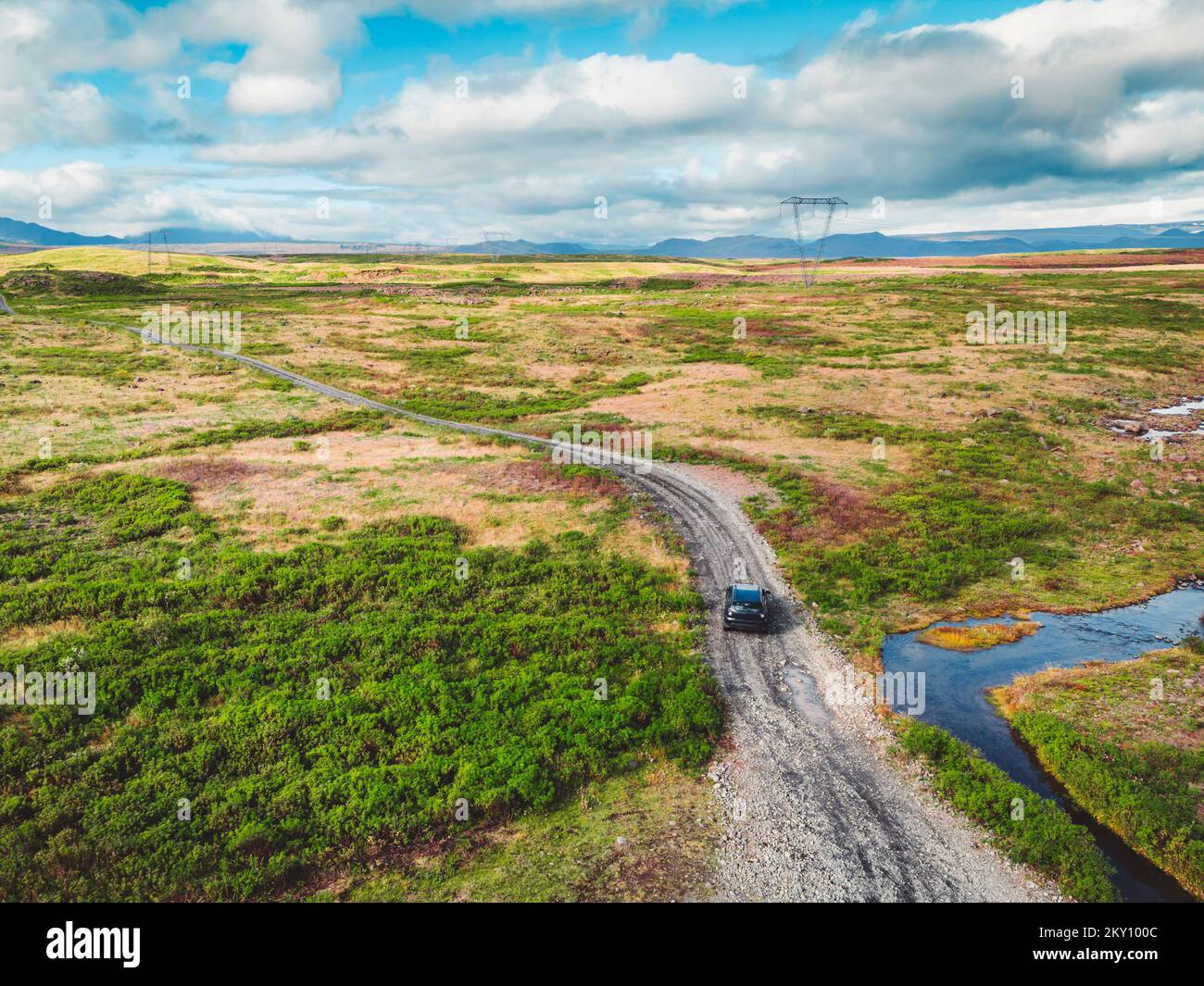 Car driving on a gravel road trough Iceland inland surrounded by ...