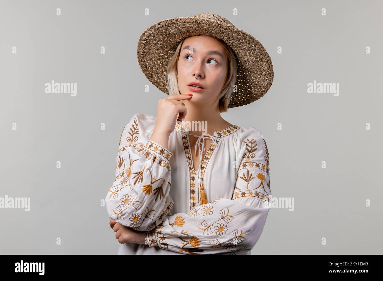 Ukrainian pensive woman on grey background. Smart thinking student girl ...