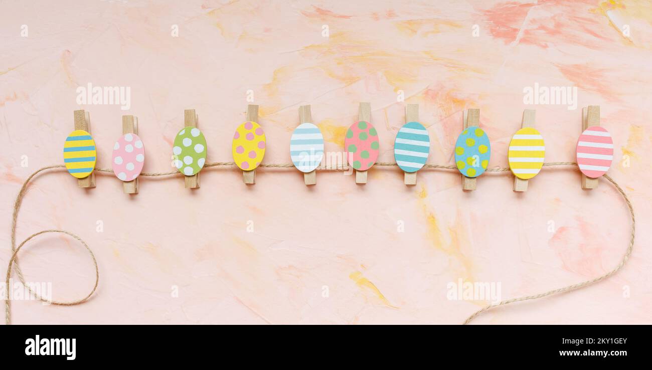 Multicolored wooden pins for notes with Easter eggs decoration on rope ...