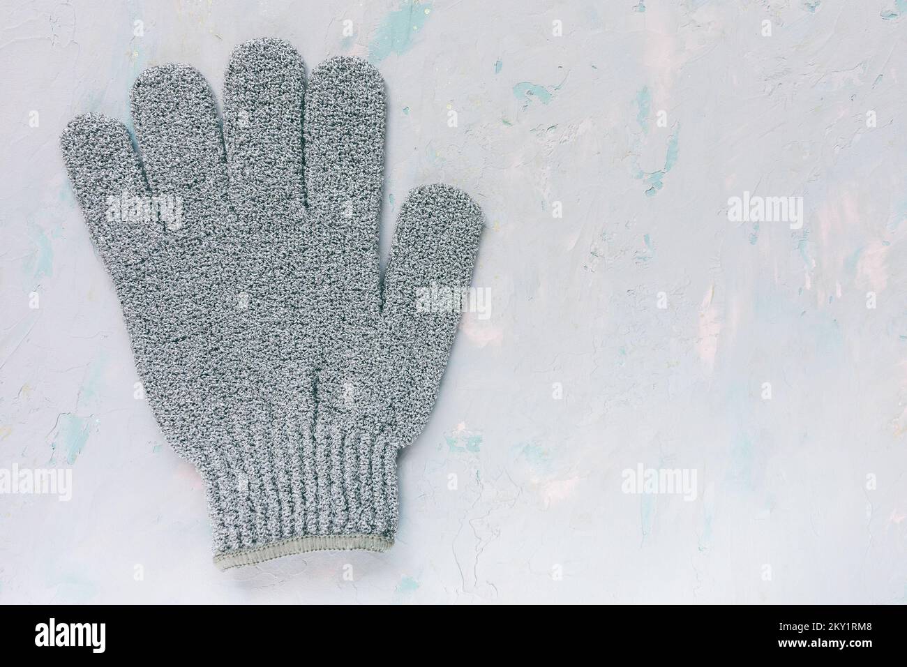 Exfoliating massage glove for shower on blue background, copy space ...