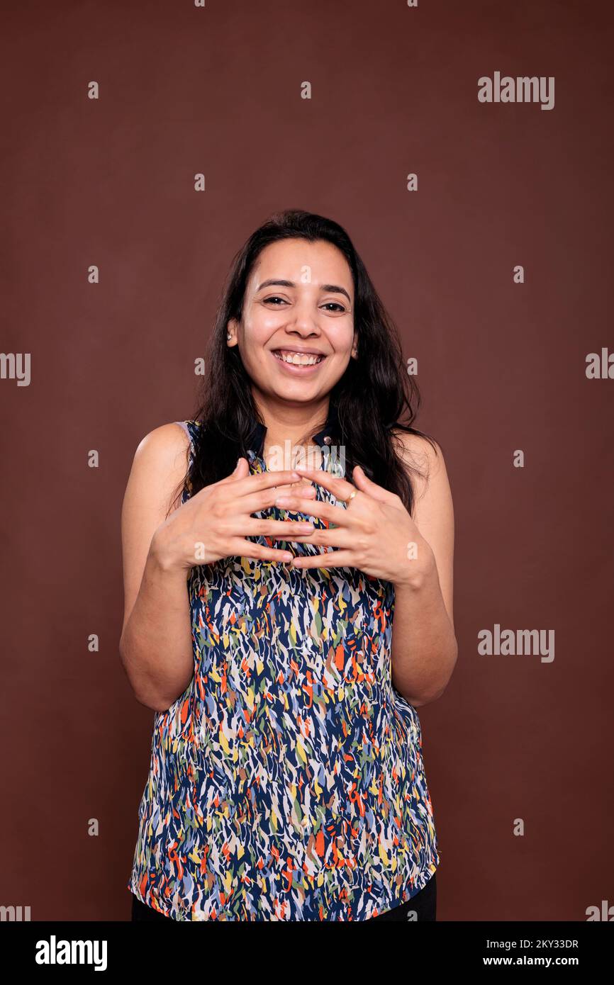 Smiling laughing indian woman intertwining fingers portrait, looking at ...