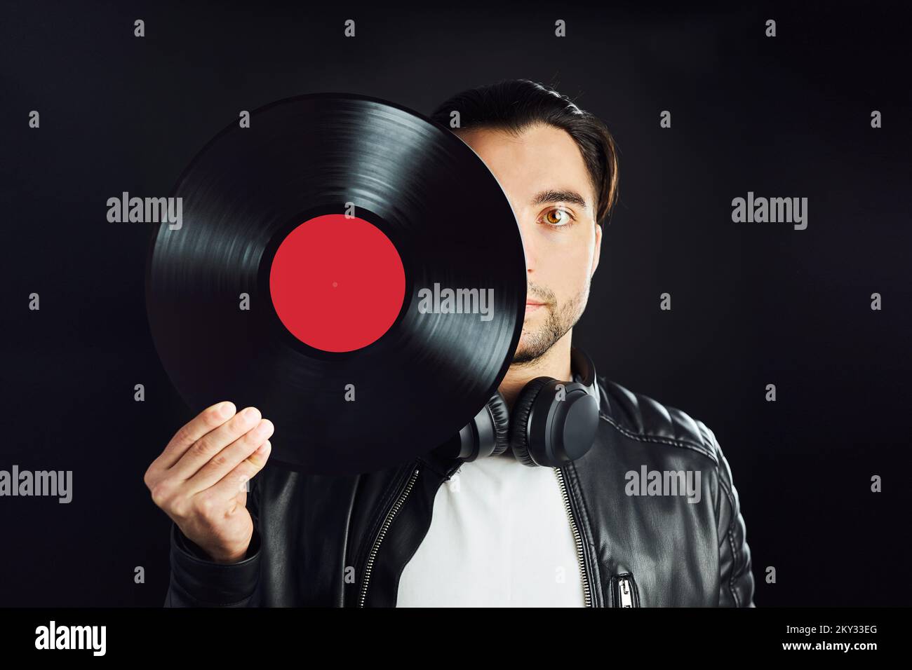 Man holding retro vinyl record covering face. Rock style. Vintage music ...