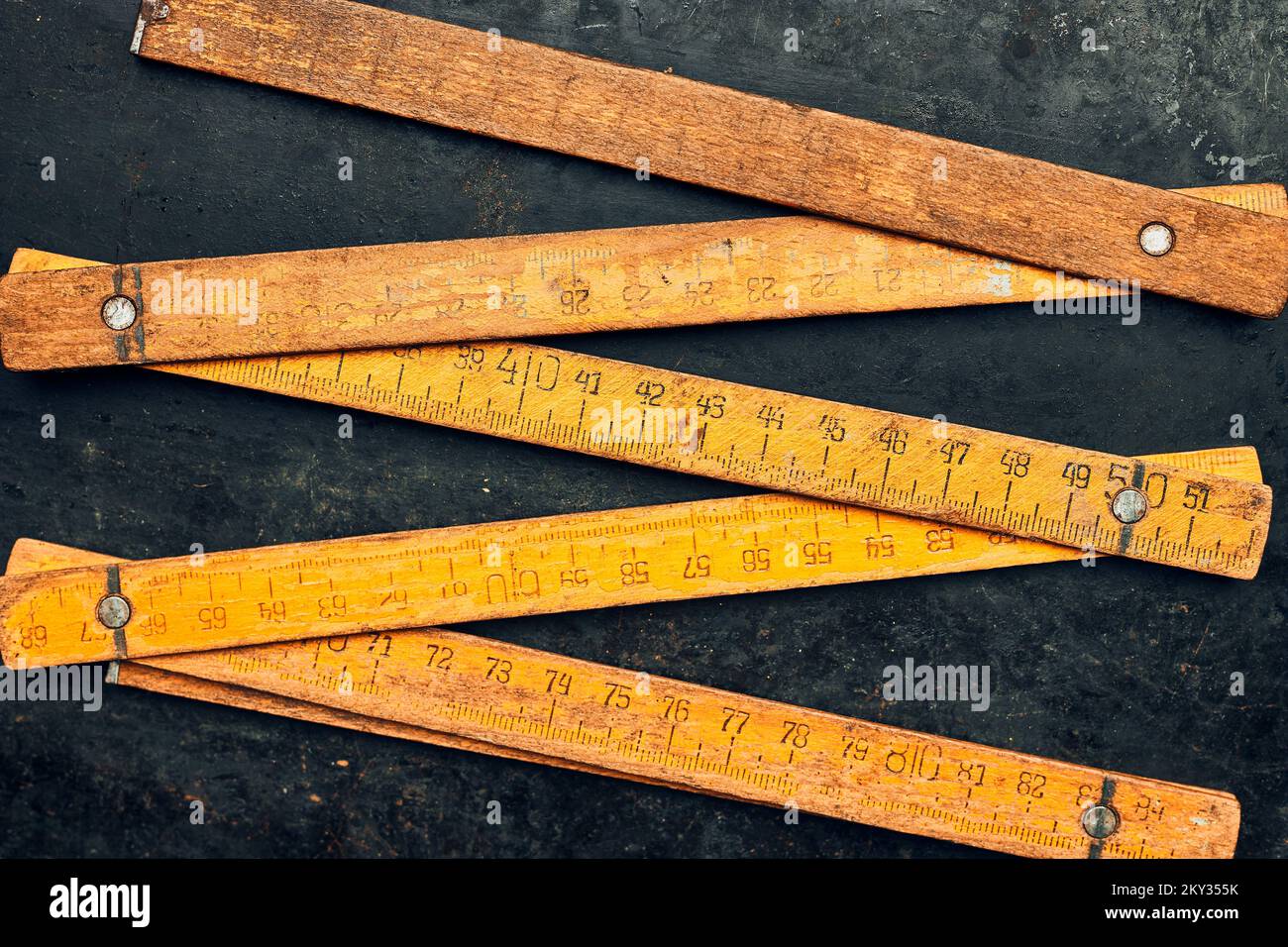 Wooden measure. Old ruler on metal surface. Measuring tool. Technical ...