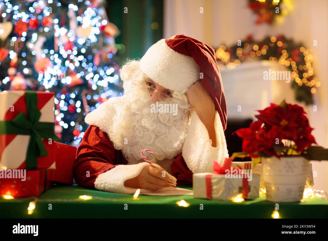 Santa Claus delivering gifts on Christmas eve. Presents under Xmas tree. Decorated living room ...