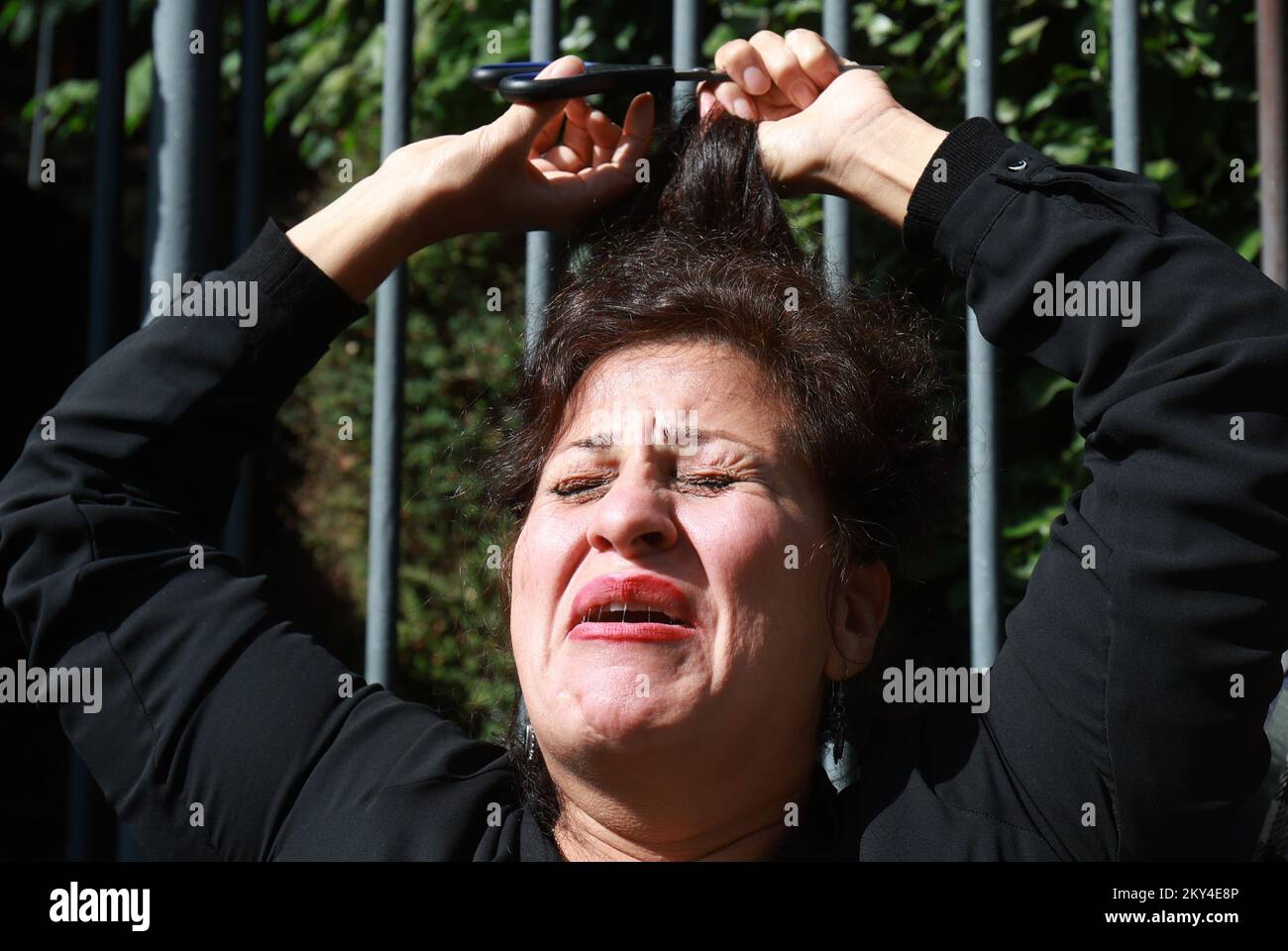 An Iranian woman living in Zagreb can be seen cutting her hair to show ...