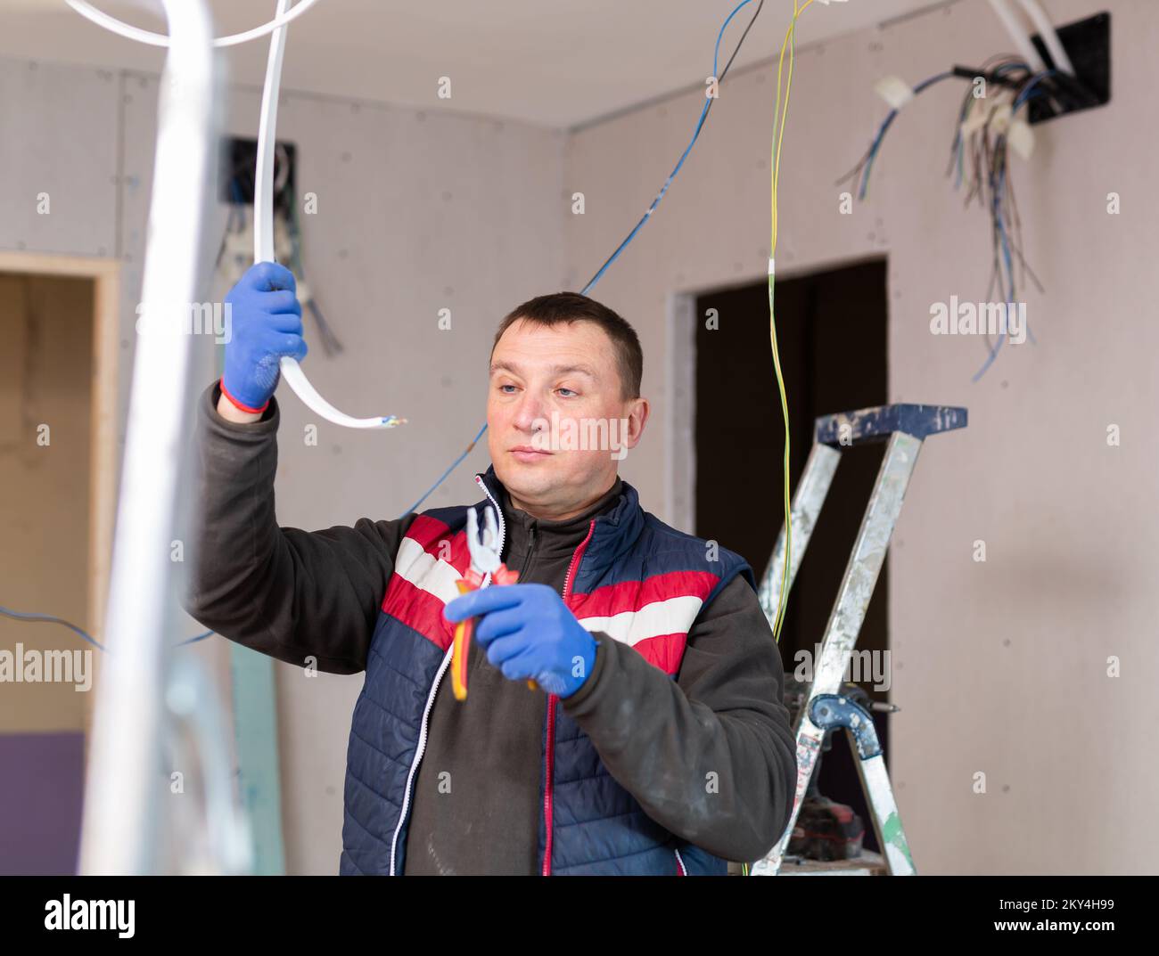 Worker repairing wires while installing electricity Stock Photo - Alamy