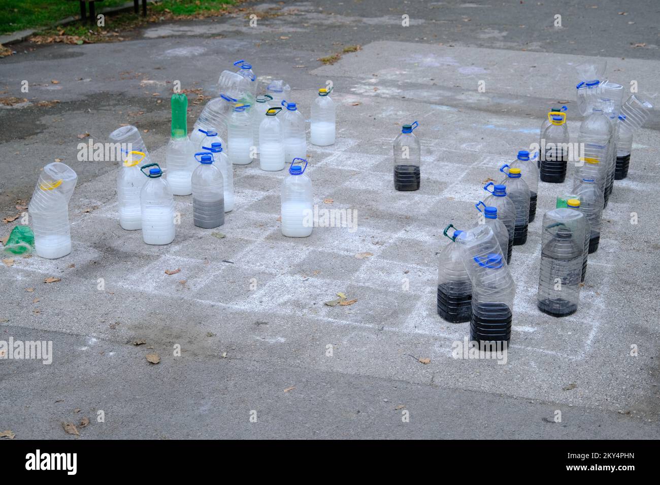 Big chess board of chalk with chess pieces made of plastic bottles seen ...