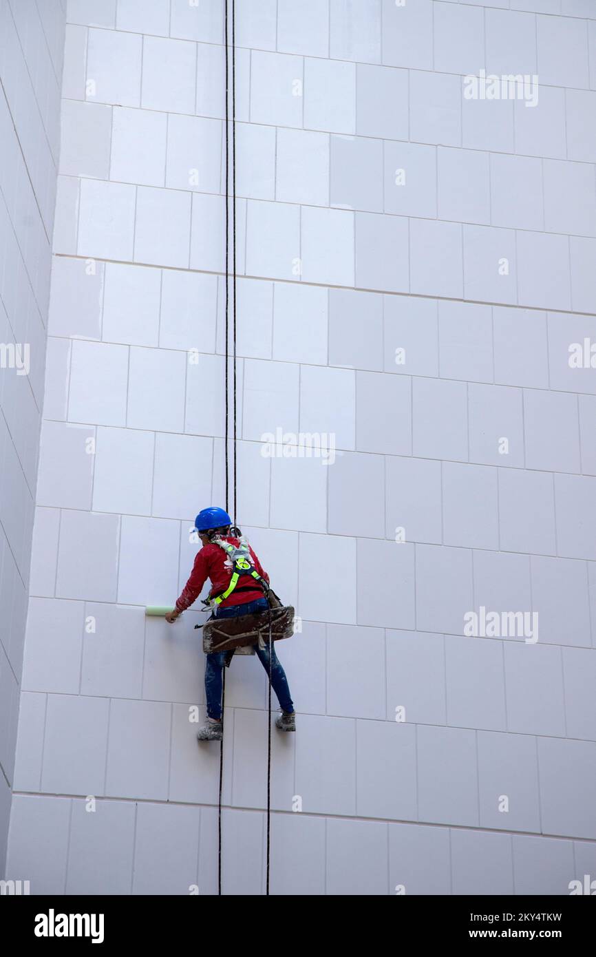 Worker suspended with safety ropes working at height Stock Photo - Alamy