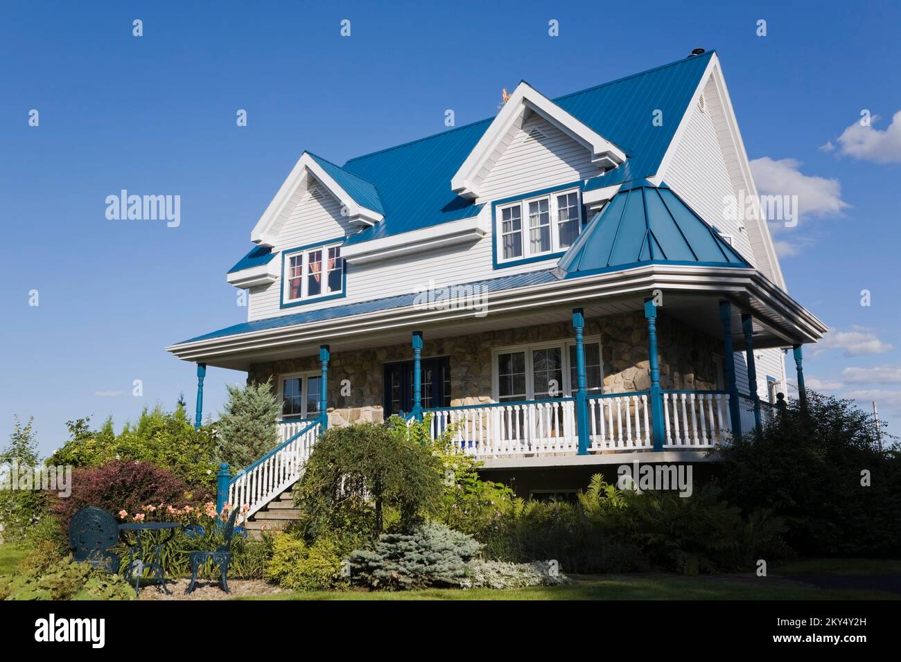 Two storied white and blue Canadiana style home with landscaped front ...
