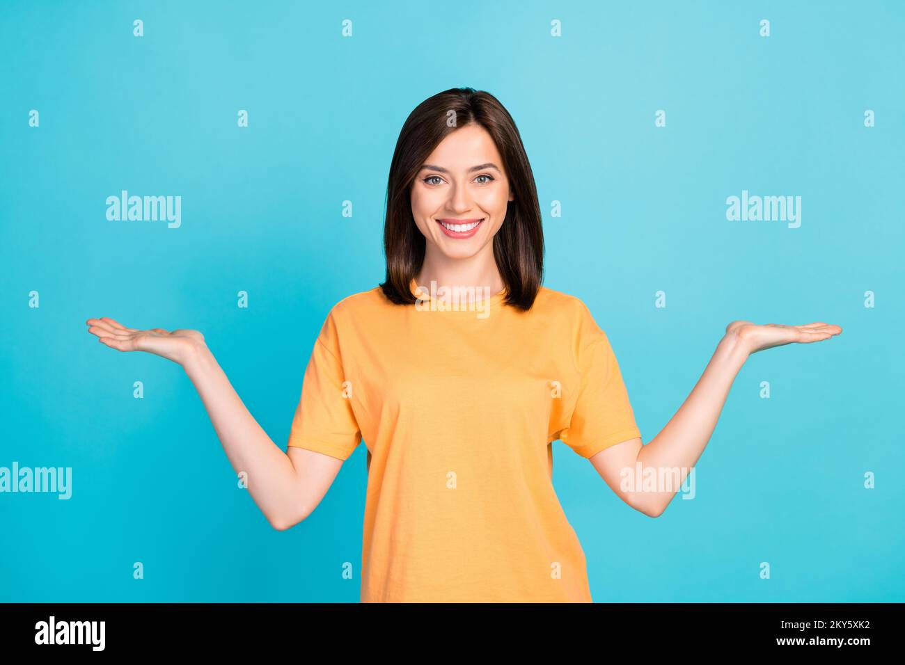 Portrait of charming positive person arms palms hold empty space vs ...