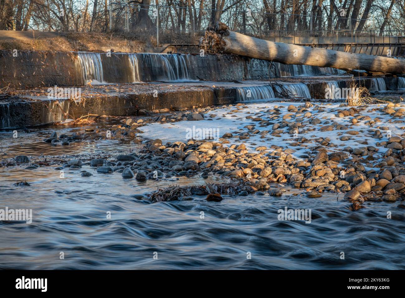 Water cascading over a diversion dam on the Poudre River with fall or ...