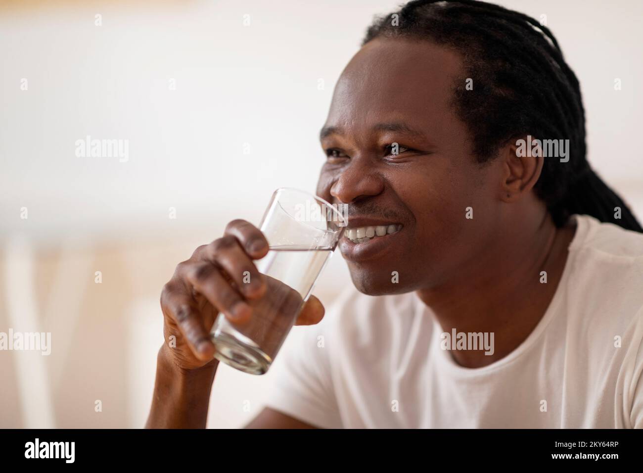Black male holding glass water hi-res stock photography and images - Alamy
