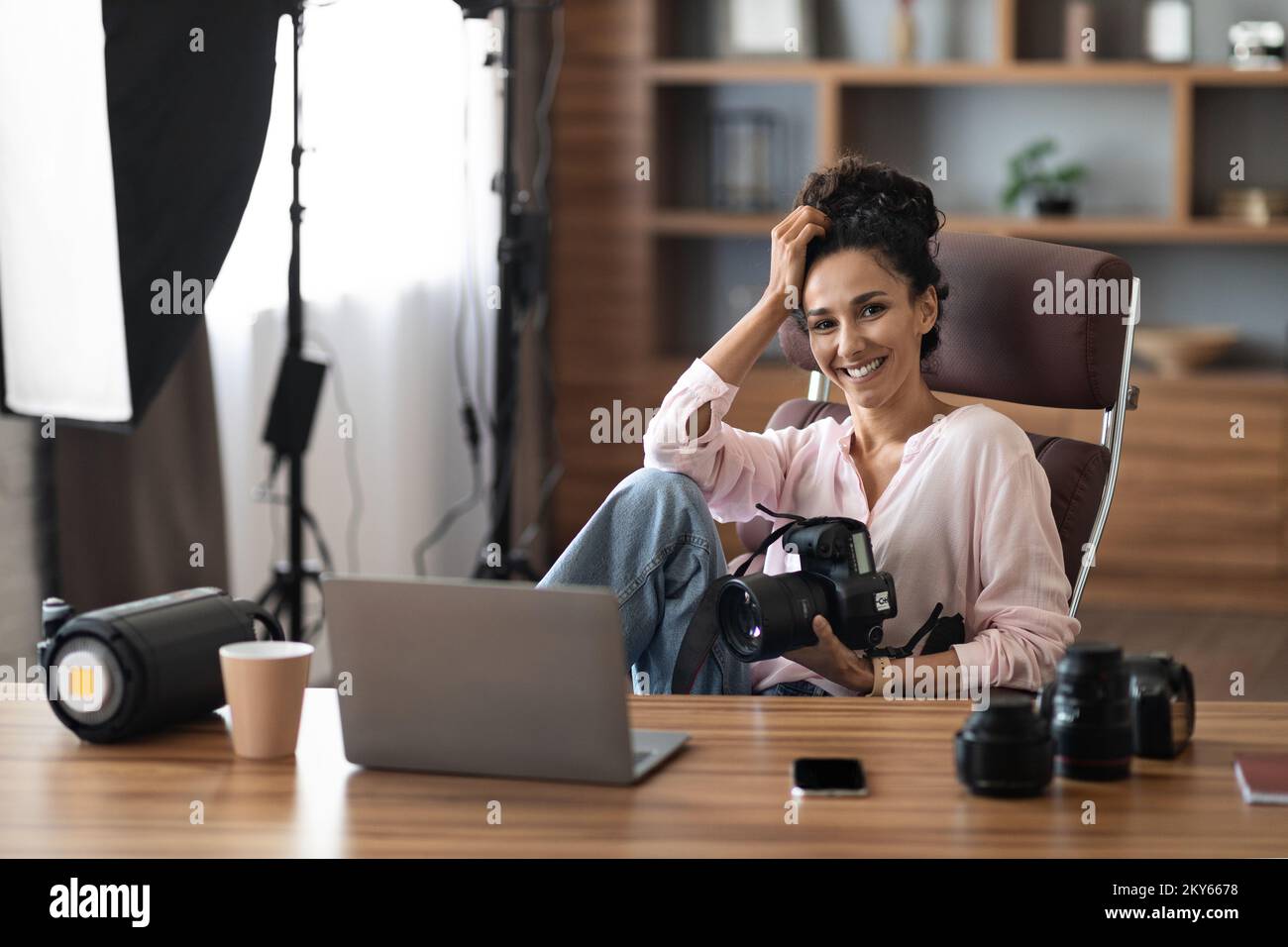 Cheerful young female designer using hi-res stock photography and ...