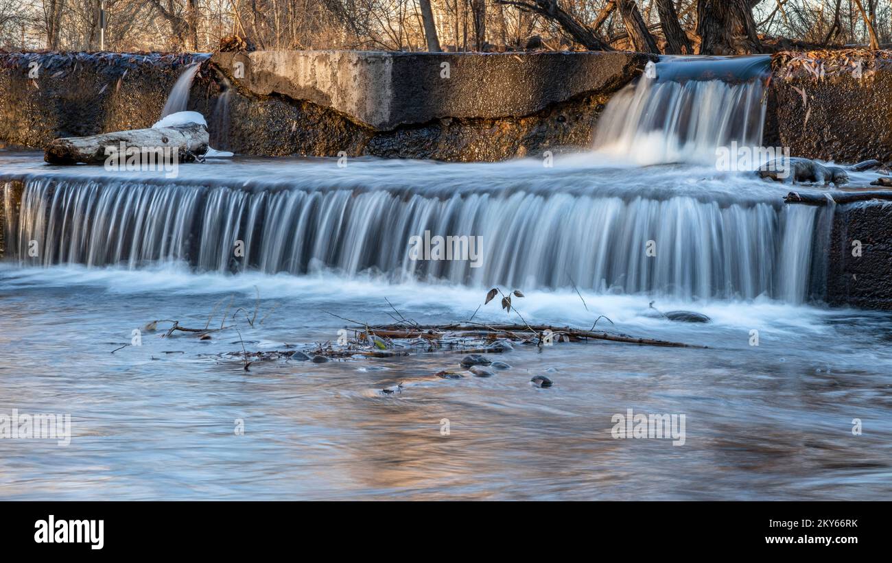 Water cascading over a diversion dam on the Poudre River with fall ...