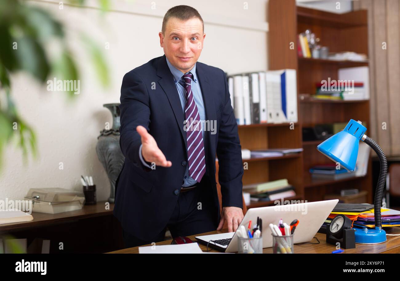 Portrait of man welcoming to company office Stock Photo - Alamy