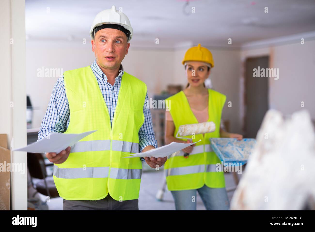 Foreman and house painter at renovating object Stock Photo - Alamy