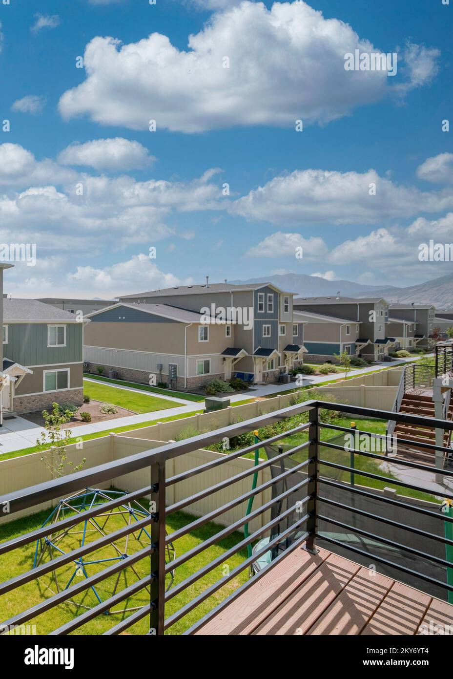 Vertical White puffy clouds View of the neighborhood houses with lawn ...