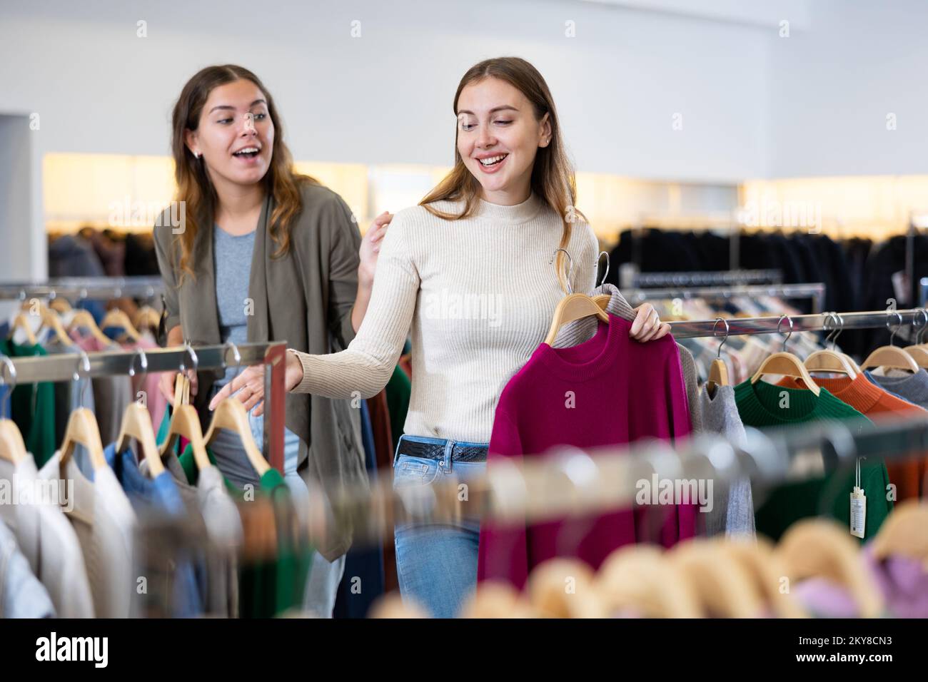 Two happy female friends are shopping in clothing store. Shopping young ...