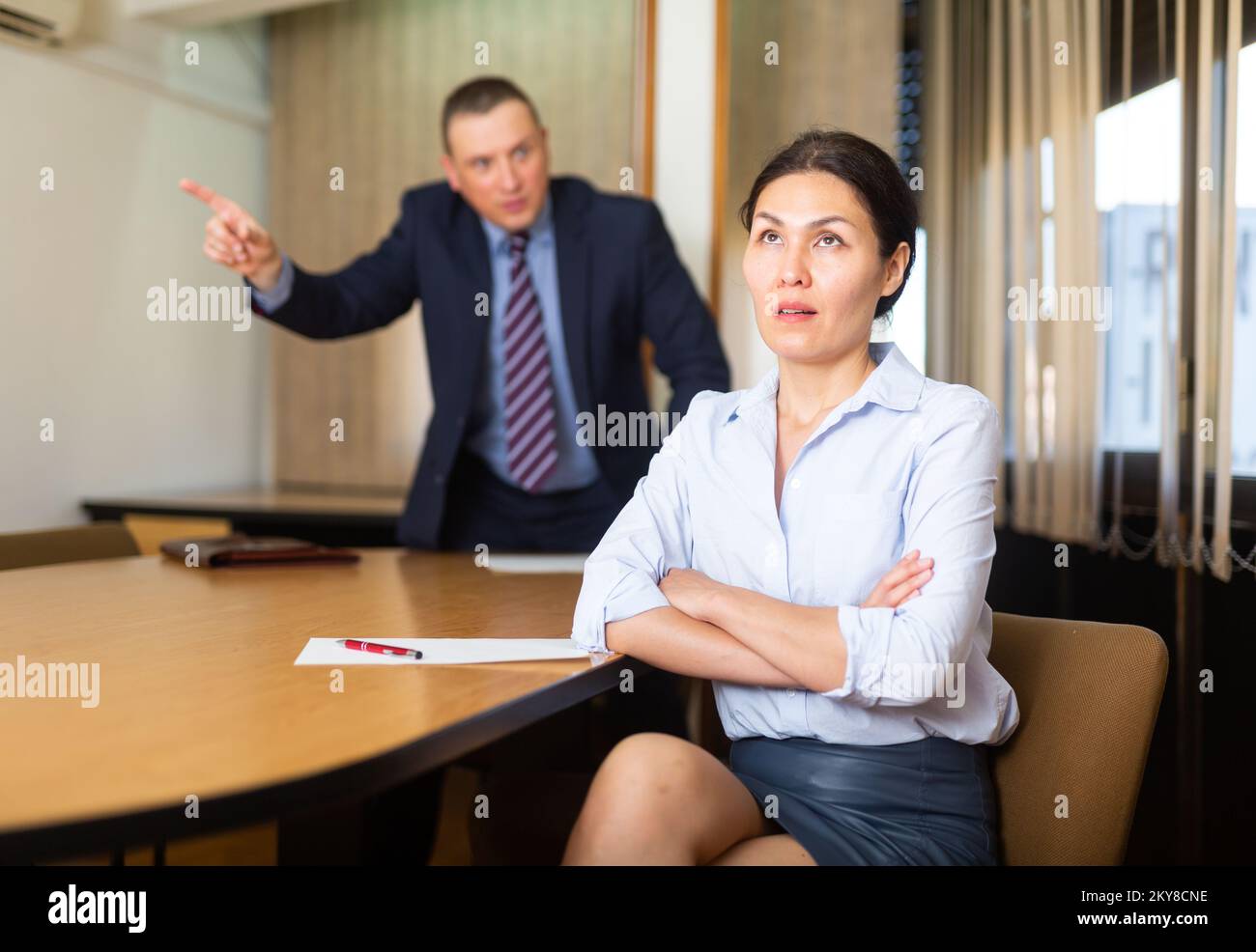 Frustrated female entrepreneur sitting in office with angry partner ...