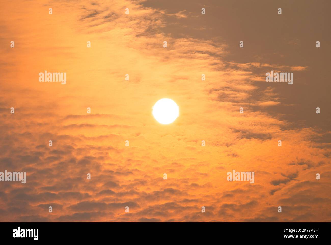 The sun rises above some clouds on a hazy summer morning Stock Photo ...