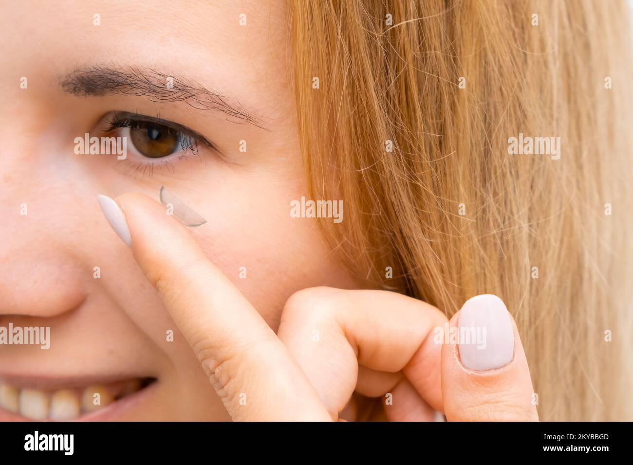 Side view of a smiling woman applying contact eye lenses Stock Photo ...
