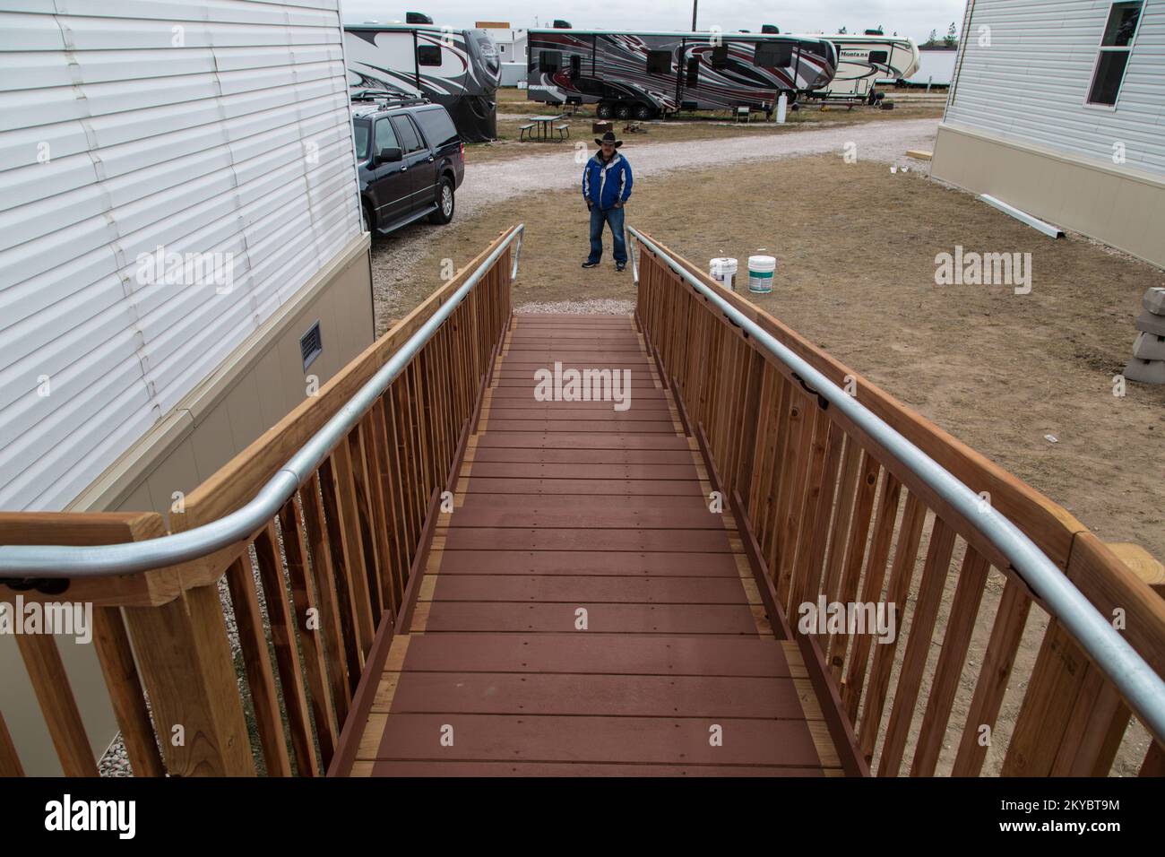 Dennis McNeer, FEMA Logistics MHU Lead, stands at the bottom of a series of platform steps for a ...