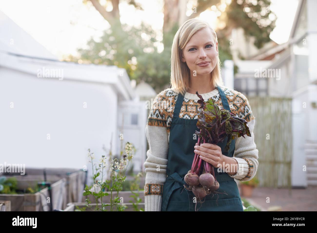 Its been a bountiful season. A young woman standing in a garden holding ...