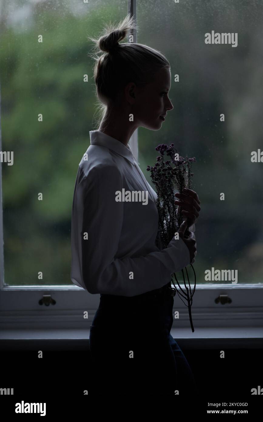 Let your imagination take flight. A young woman standing by a window ...