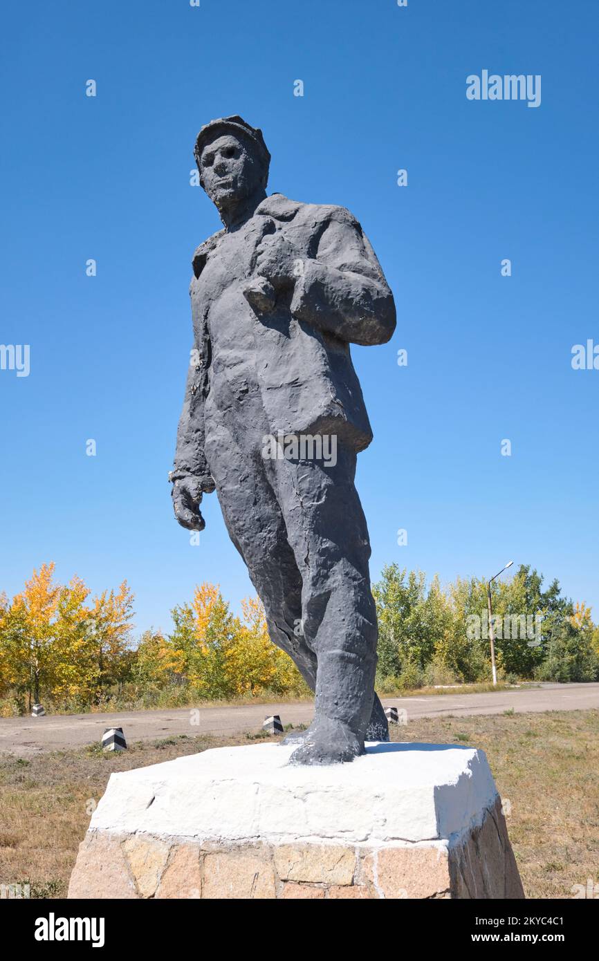 A black painted concrete statue of a generic, typical Soviet era coal ...
