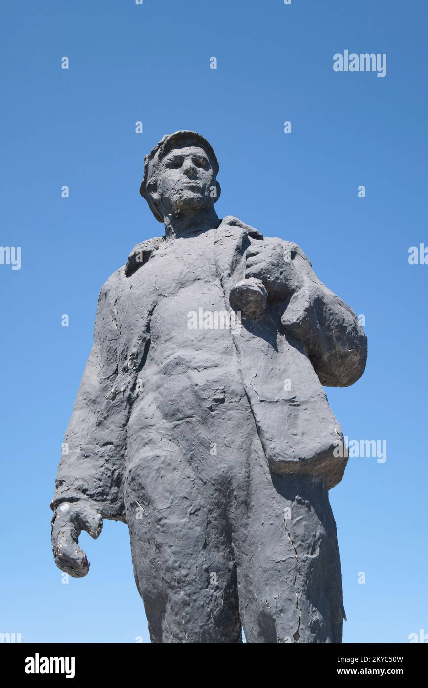 A black painted concrete statue of a generic, typical Soviet era coal ...