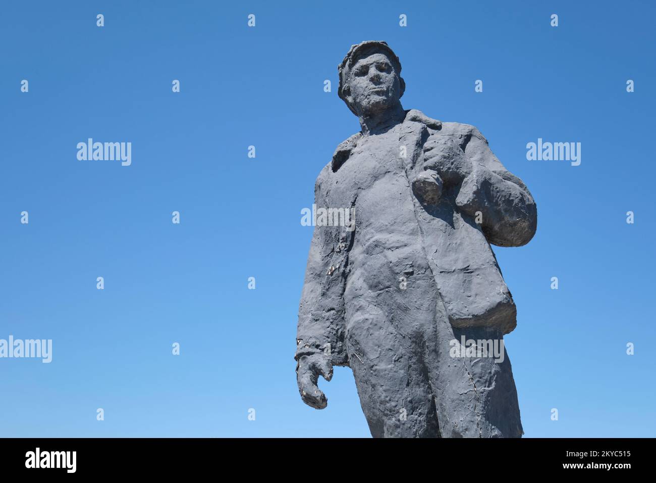 A black painted concrete statue of a generic, typical Soviet era coal ...
