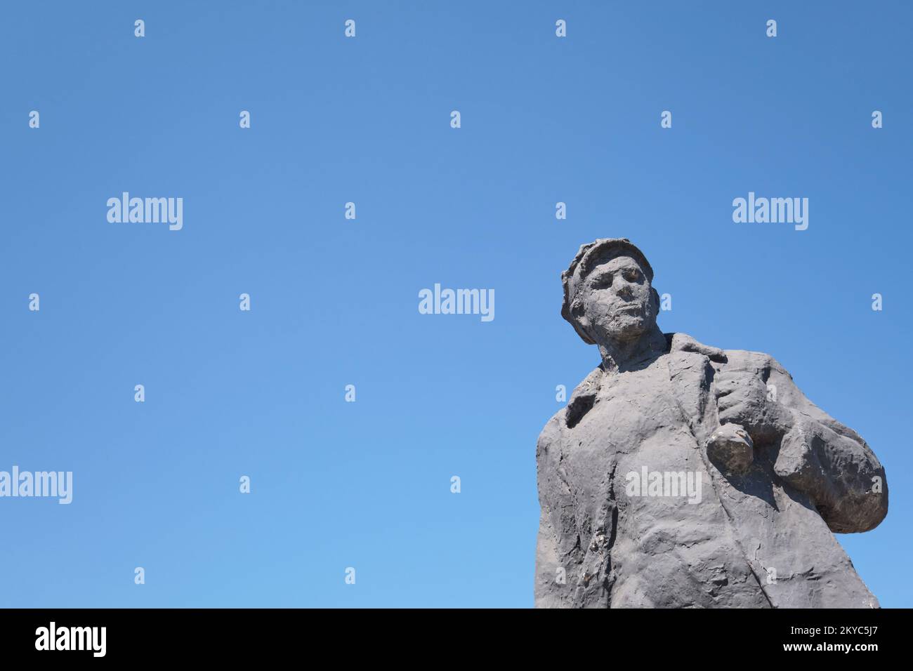 A black painted concrete statue of a generic, typical Soviet era coal ...
