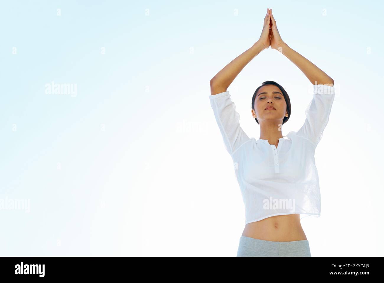 Finding balance. A young woman performing a yoga routine on the beach ...