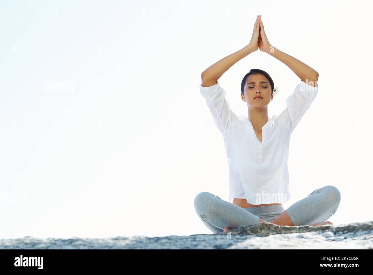Absorbing natures peace. A young woman performing a yoga routine on the ...