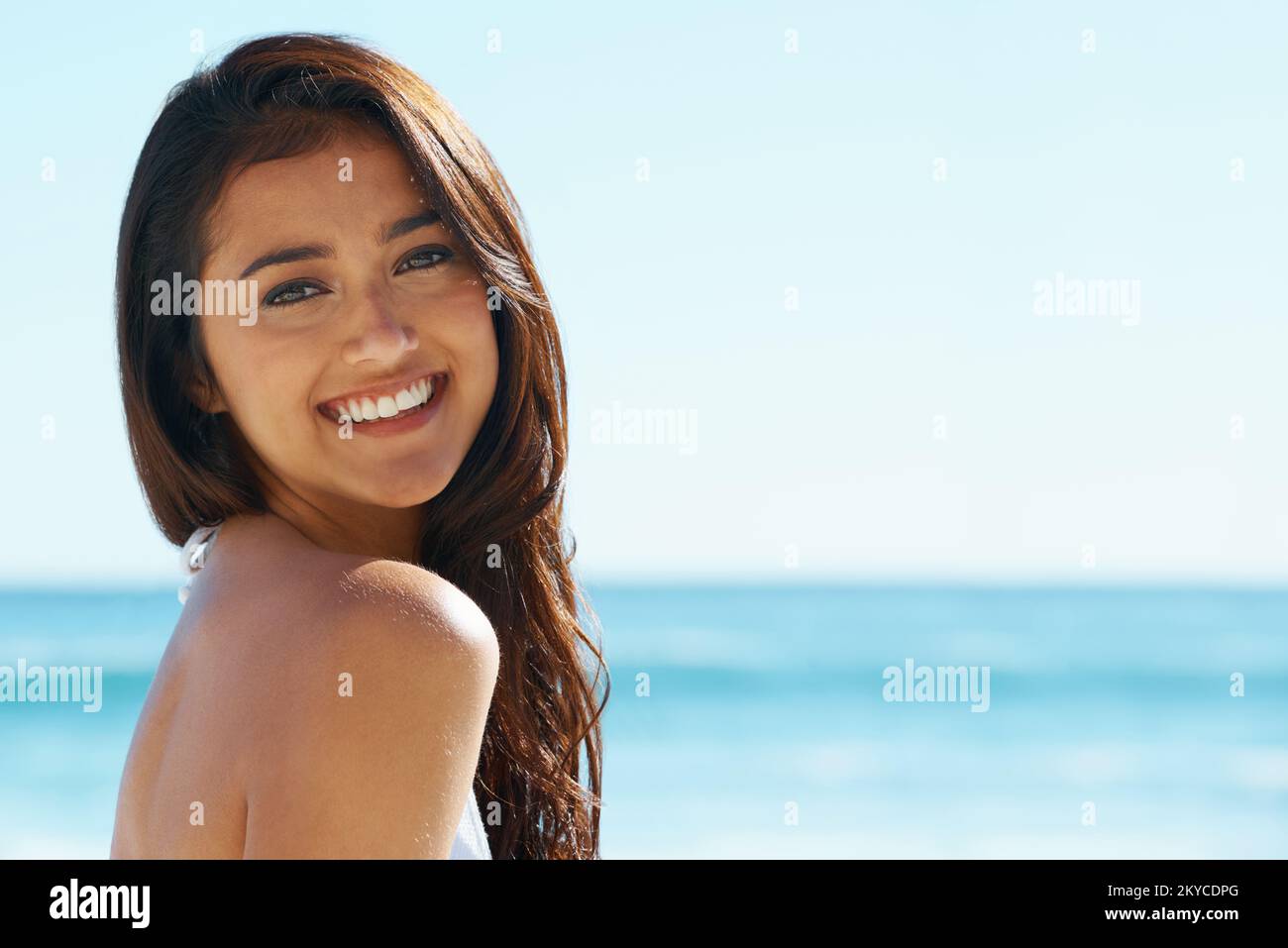 Catching a tan and feeling great. A gorgeous young woman standing on ...