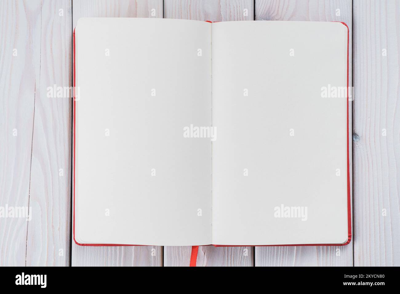 Red diary, text book with white paper pages on wooden table background ...
