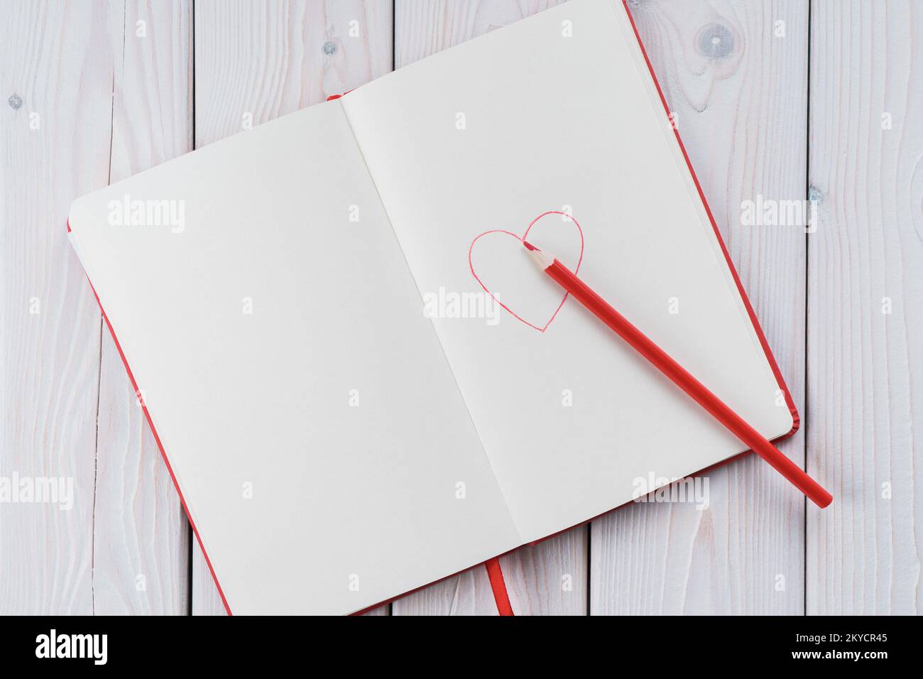 Red diary notebook with white papers, craft pencil and red drawing ...
