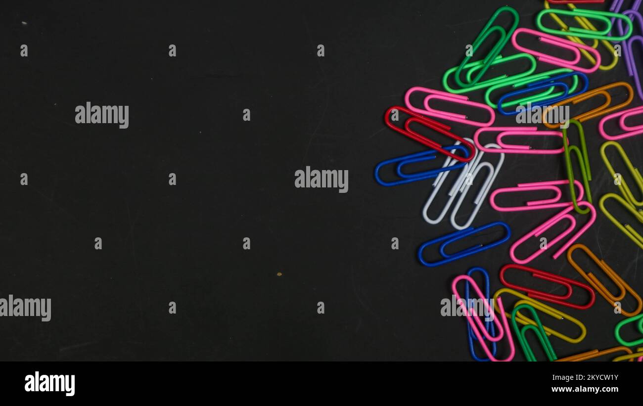 Colorful paper clips isolated on black background Stock Photo - Alamy
